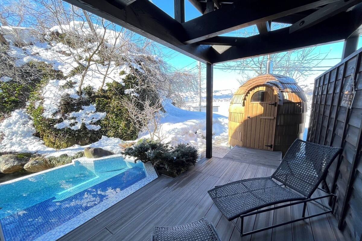 Espaço ao ar livre coberto com piscina, deck de madeira e sauna.