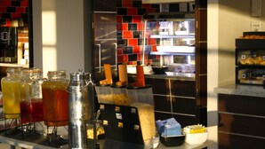 Um balcão de pequeno-almoço com diversas opções de comida e bebidas.