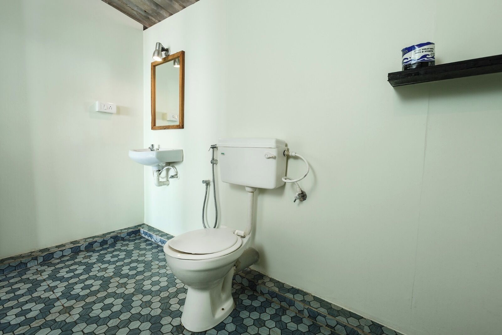 Casa de banho com sanita, lavatório e chuveiro.