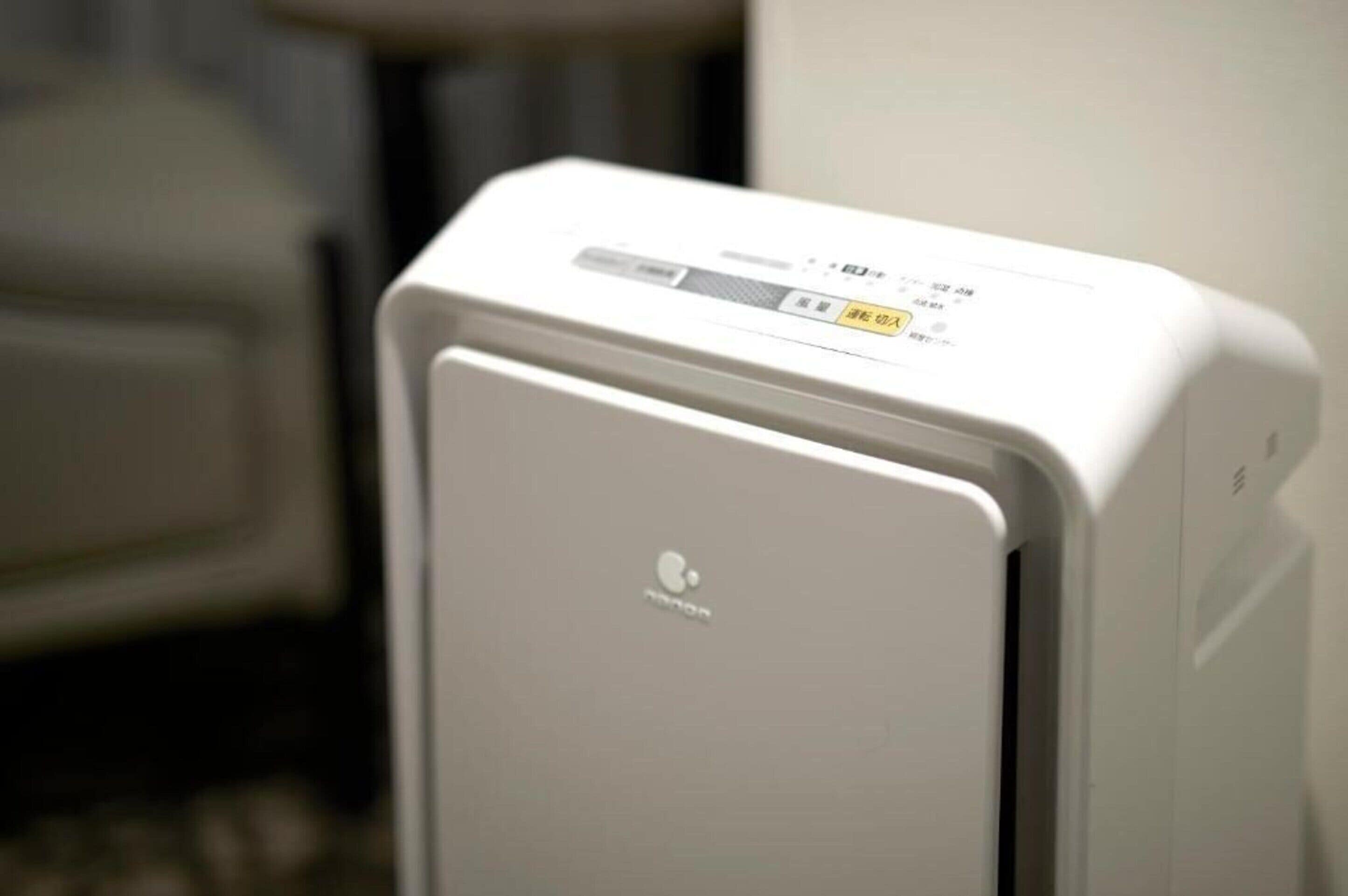 Um dispositivo branco, compacto e com design moderno, com tela digital e um pequeno logotipo na frente.