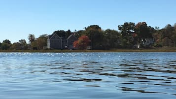 Um lago calmo com casas ao fundo.