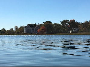 Um lago calmo com casas ao fundo.