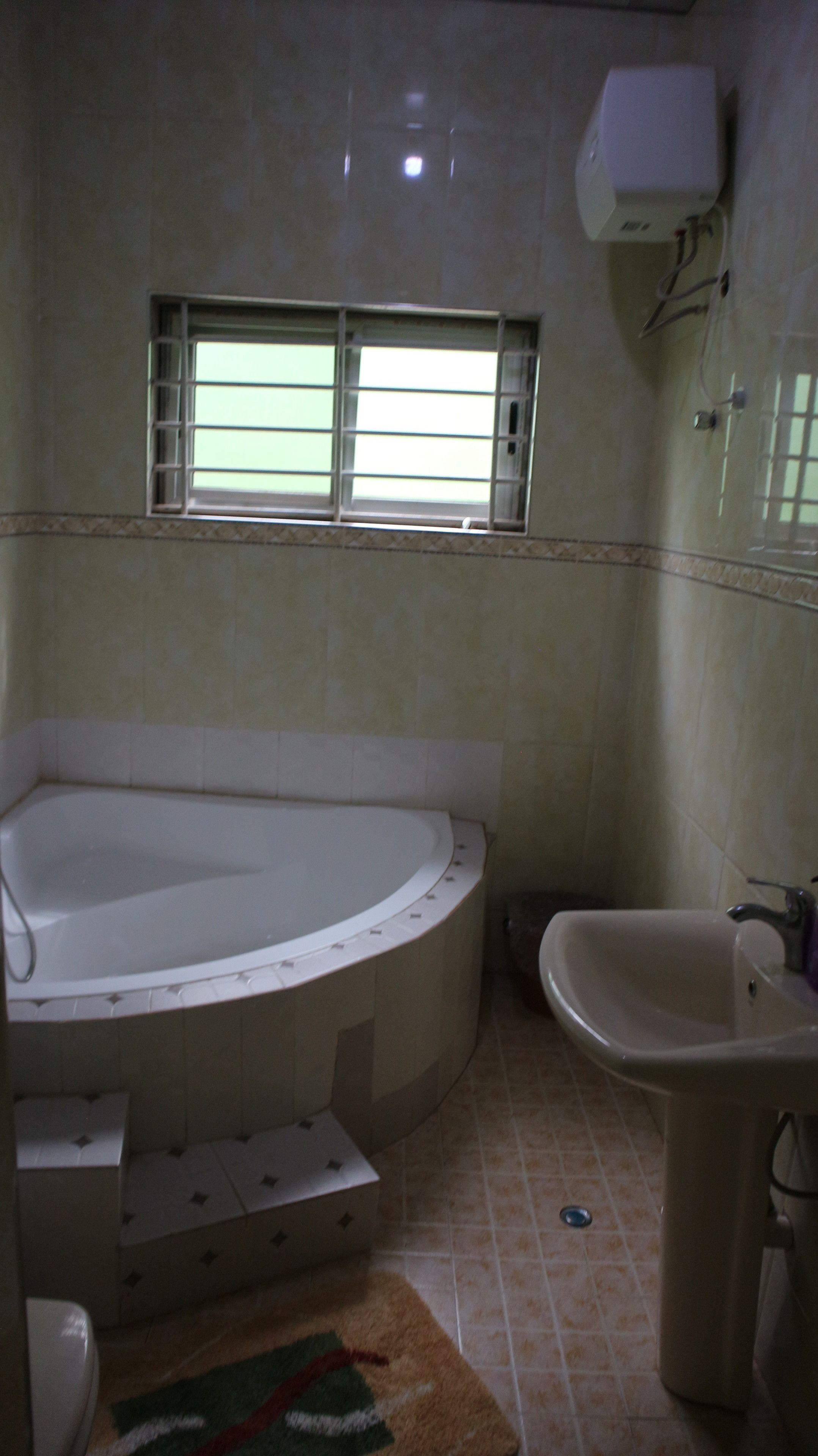 Casa de banho com banheira, lavatório e janela.