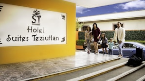 Entrada de hotel com uma placa indicando Hotel Suites Teziuhtlan.