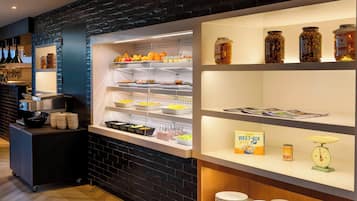 Um balcão de café da manhã com diversos alimentos e acompanhamentos.