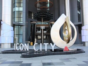 Um edifício moderno com uma grande escultura circular em frente.