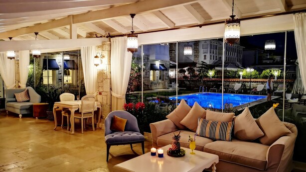 Uma sala de estar aconchegante com vista para a piscina, equipada com sofás, cadeiras e uma mesa de centro.