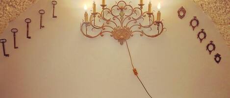 Um quarto com um aplique decorativo e vários almofadas.