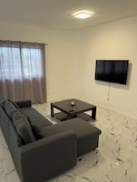 Apartamento, 2 quartos | Área de estar | TV de tela plana