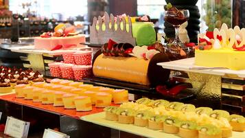 Diversas sobremesas e doces expostos em uma mesa de buffet.