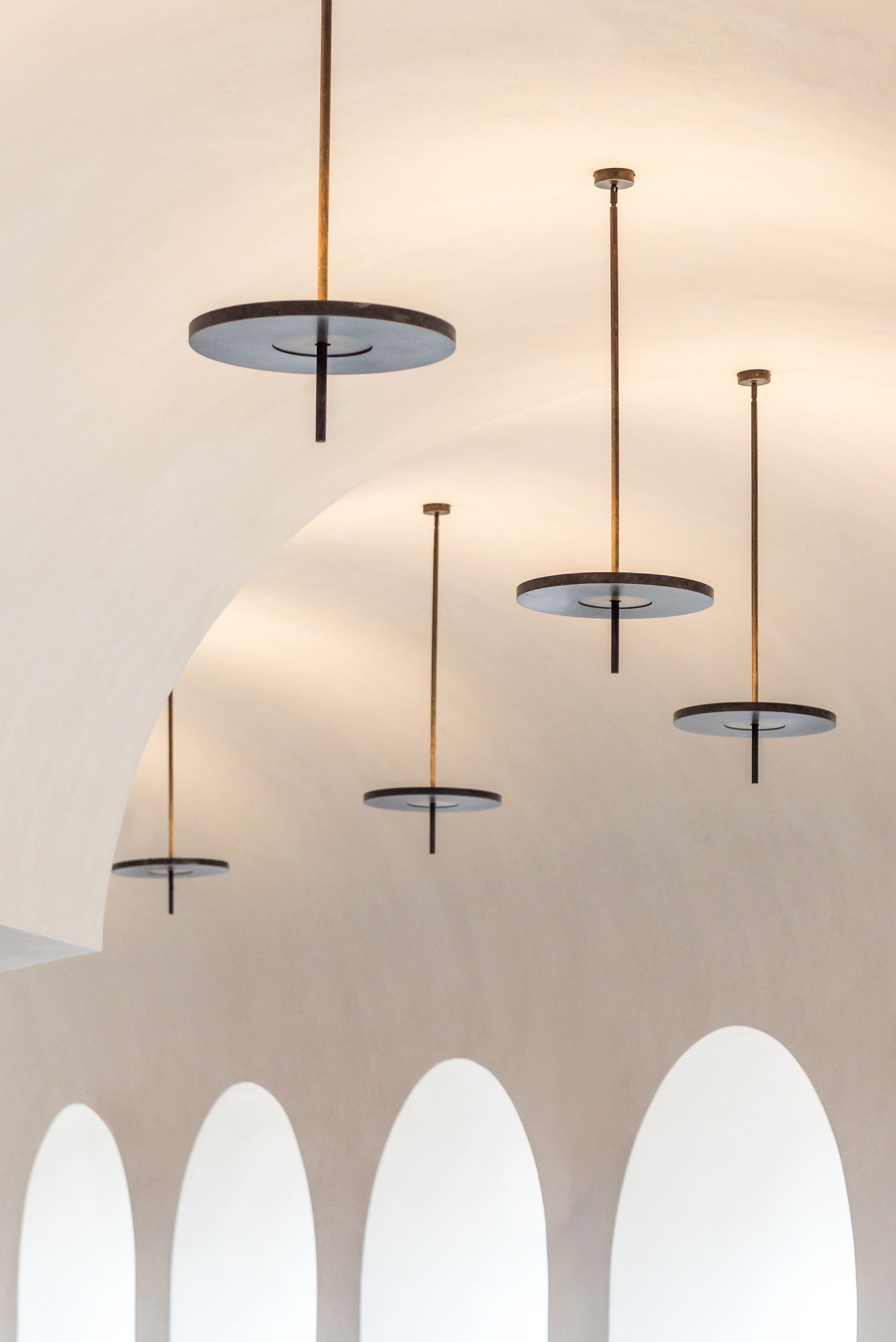 Teto com luminárias circulares e arcos.