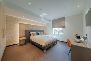 Quarto moderno com cama, escrivaninha e janela.