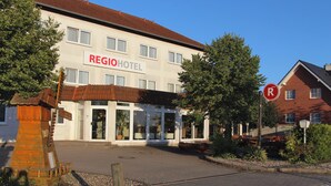 Um hotel com uma placa indicando 'REGIOHOTEL' e uma placa de proibido estacionar por perto.