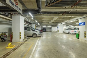 Garagem subterrânea com vários níveis, sinalização clara, incluindo placa de proibido estacionar e setas indicativas.