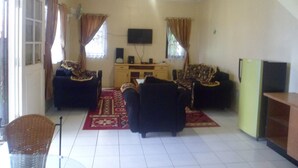 Sala de estar com dois sofás, uma televisão e um frigorífico.