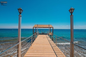 Praia particular, espreguiçadeiras, guarda-sóis, toalhas de praia 