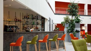 Uma área de bar com banquetas e diversos tipos de garrafas.