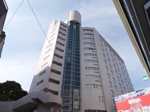 Um edifício alto e moderno com fachada curva e várias sacadas.