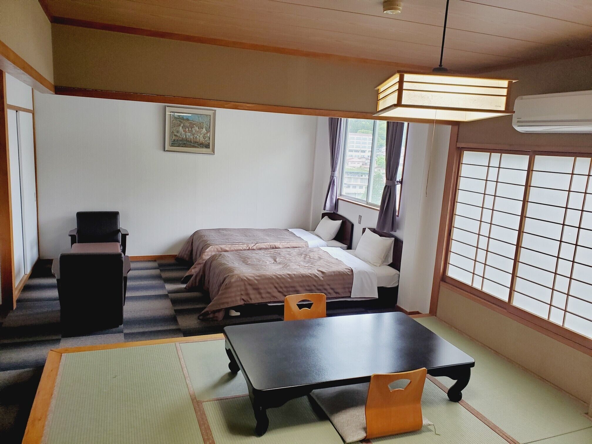 Um quarto em estilo japonês tradicional, com tatames no chão, uma mesa baixa e uma cama com futon.