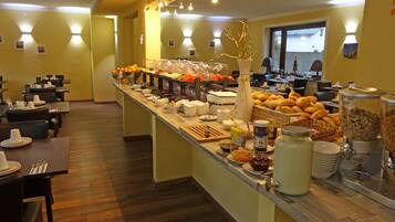 Uma mesa de buffet com diversos alimentos e uma estação de café.