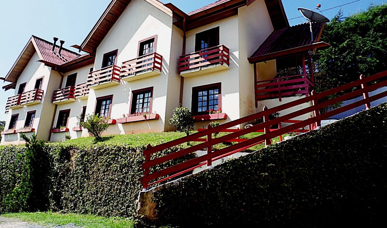 Um edifício com várias andares, varandas e uma escadaria vermelha.