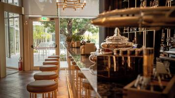 Zona de bar com banquetas, balcão e vista para o exterior.