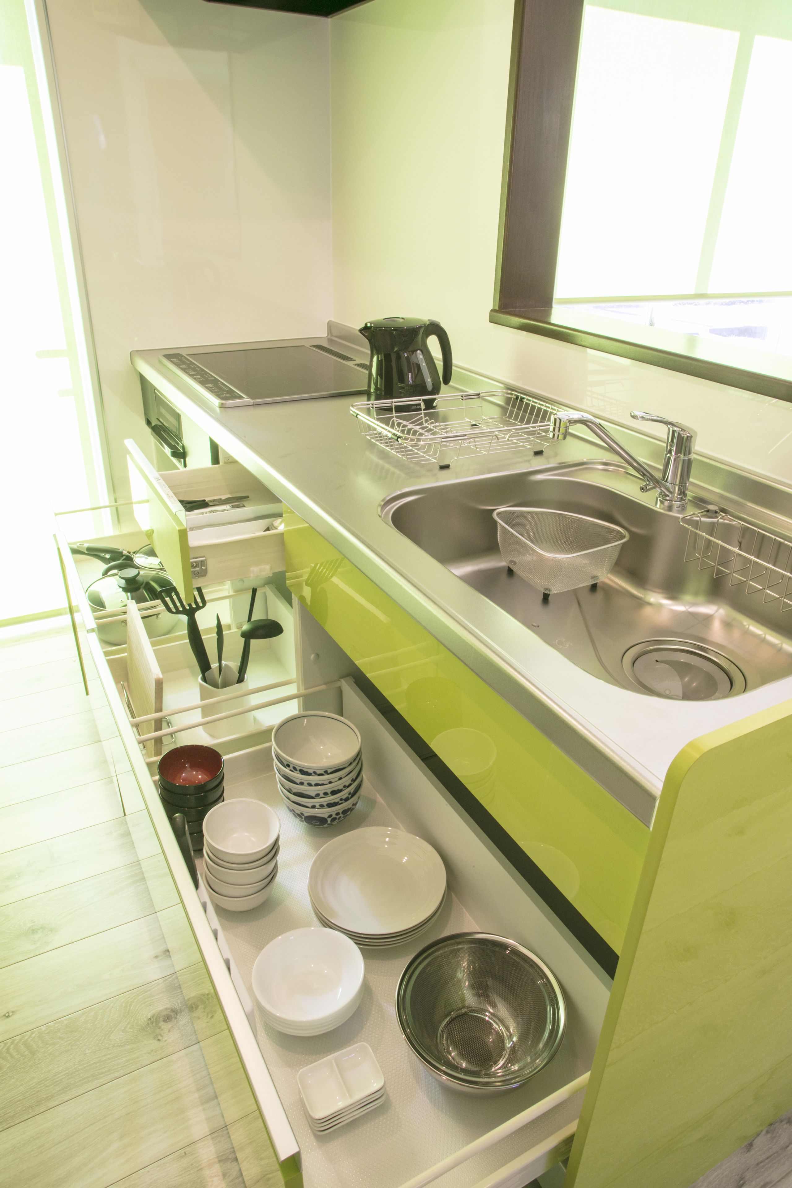 Uma cozinha moderna com uma pia de aço inoxidável, uma cafeteira e diversos pratos e utensílios.
