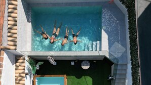 Vista aérea de uma piscina com três pessoas boiando.