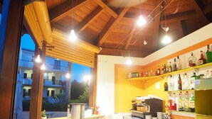 Uma cozinha com vigas de madeira, um espaço de bar com garrafas e vista para um edifício.