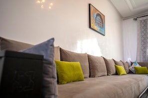 Um sofá bege com várias almofadas em uma sala de estar.