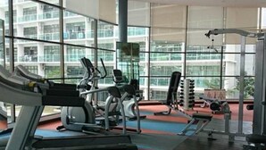 Uma academia com esteiras, bicicletas ergométricas e aparelhos de musculação.