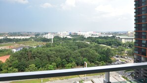 Paisagem urbana com áreas verdes e edifícios, incluindo um prédio alto com detalhes em laranja.