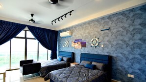 Quarto com duas camas, ventilador de teto e uma janela grande com cortinas.