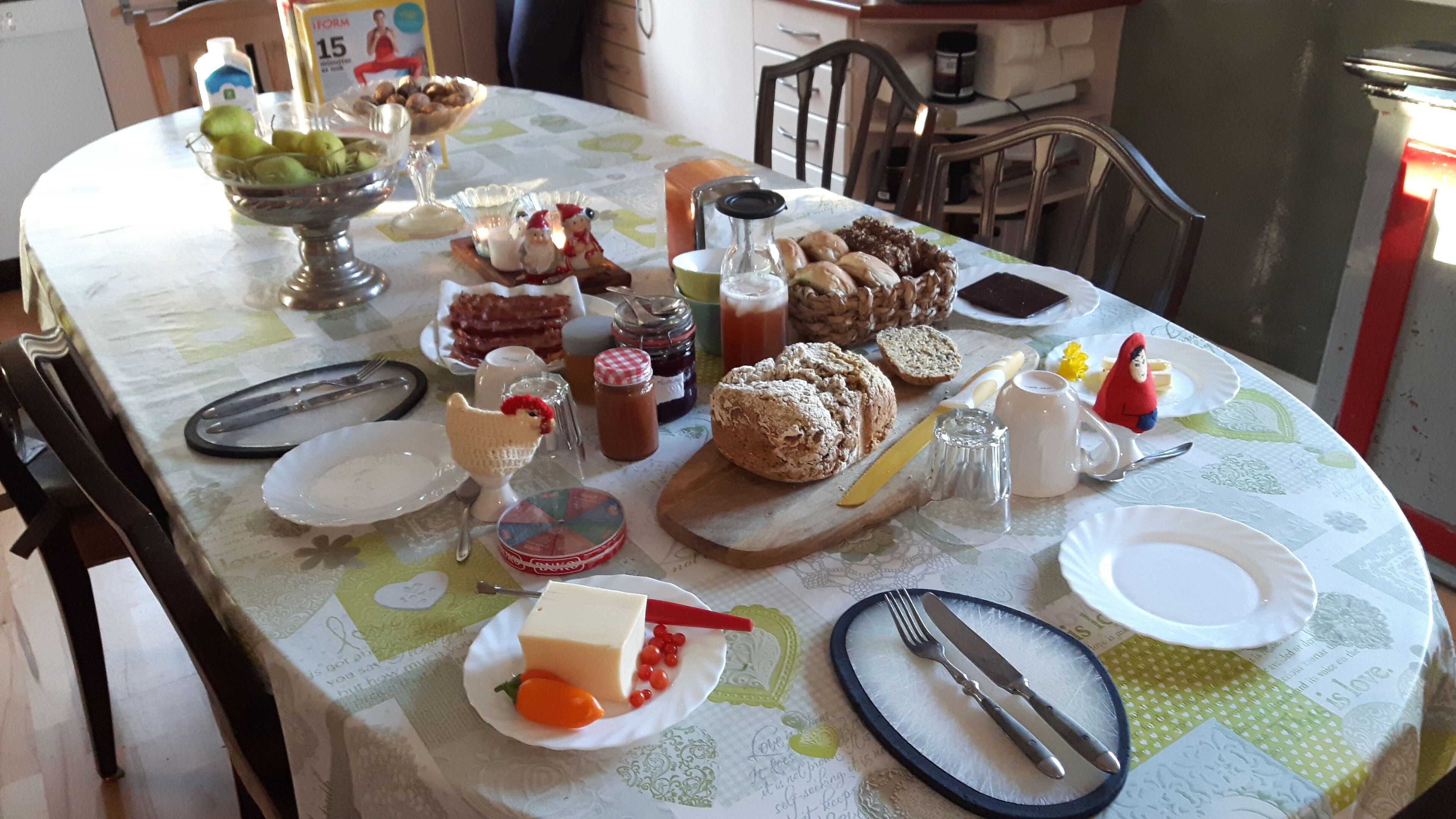 Uma mesa de jantar posta com diversos alimentos, utensílios e objetos decorativos.