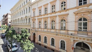 Um edifício de vários andares com arquitetura clássica, apresentando janelas em arco e molduras decorativas.