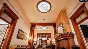 Uma sala de estar aconchegante com lareira, móveis de madeira e uma janela de vitrais.
