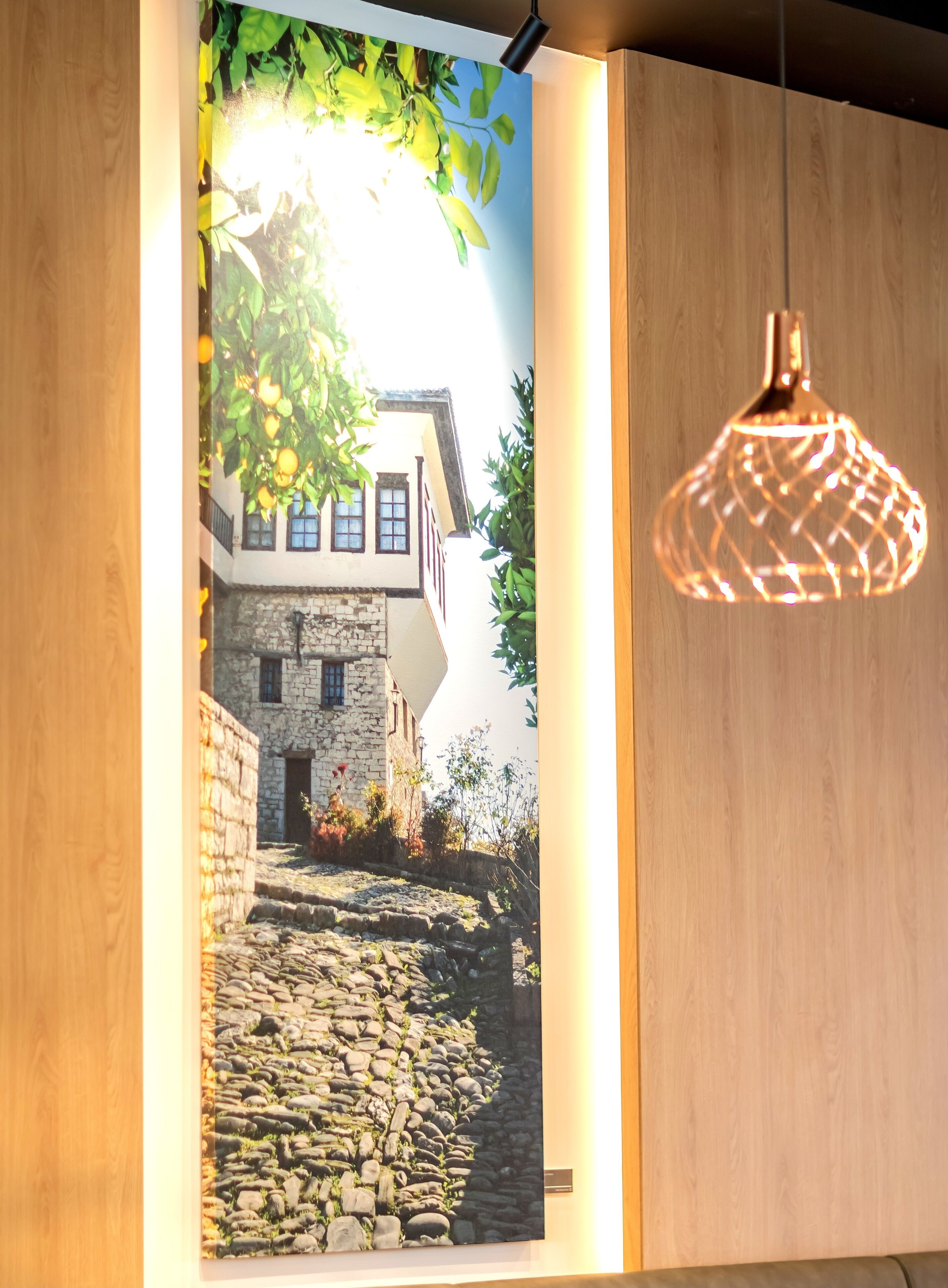Um quarto com parede de pedra, um armário de madeira e um lustre.