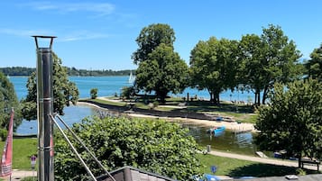 Um parque à beira do lago com um coreto, mesas para piquenique e um cais para barcos.