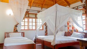Quarto com duas camas de madeira, cada uma com dossel.