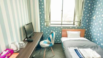 Quarto de hotel com cama, escrivaninha, computador, cadeira e janela com cortinas.