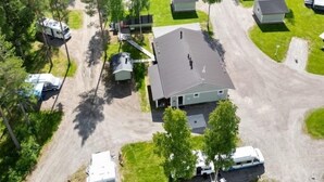 Vista aérea de um camping com veículos recreativos, casas móveis e um edifício central.