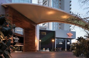 Um Hard Rock Cafe com design arquitetônico moderno, apresentando uma cobertura curva e uma grande fachada de vidro.