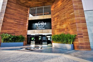 Fachada do Hotel Hard Rock Guadalajara com design moderno, grandes janelas e plantas em vasos.