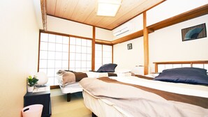 Um quarto tradicional japonês com tatame, um biombos shoji e uma cama futon.