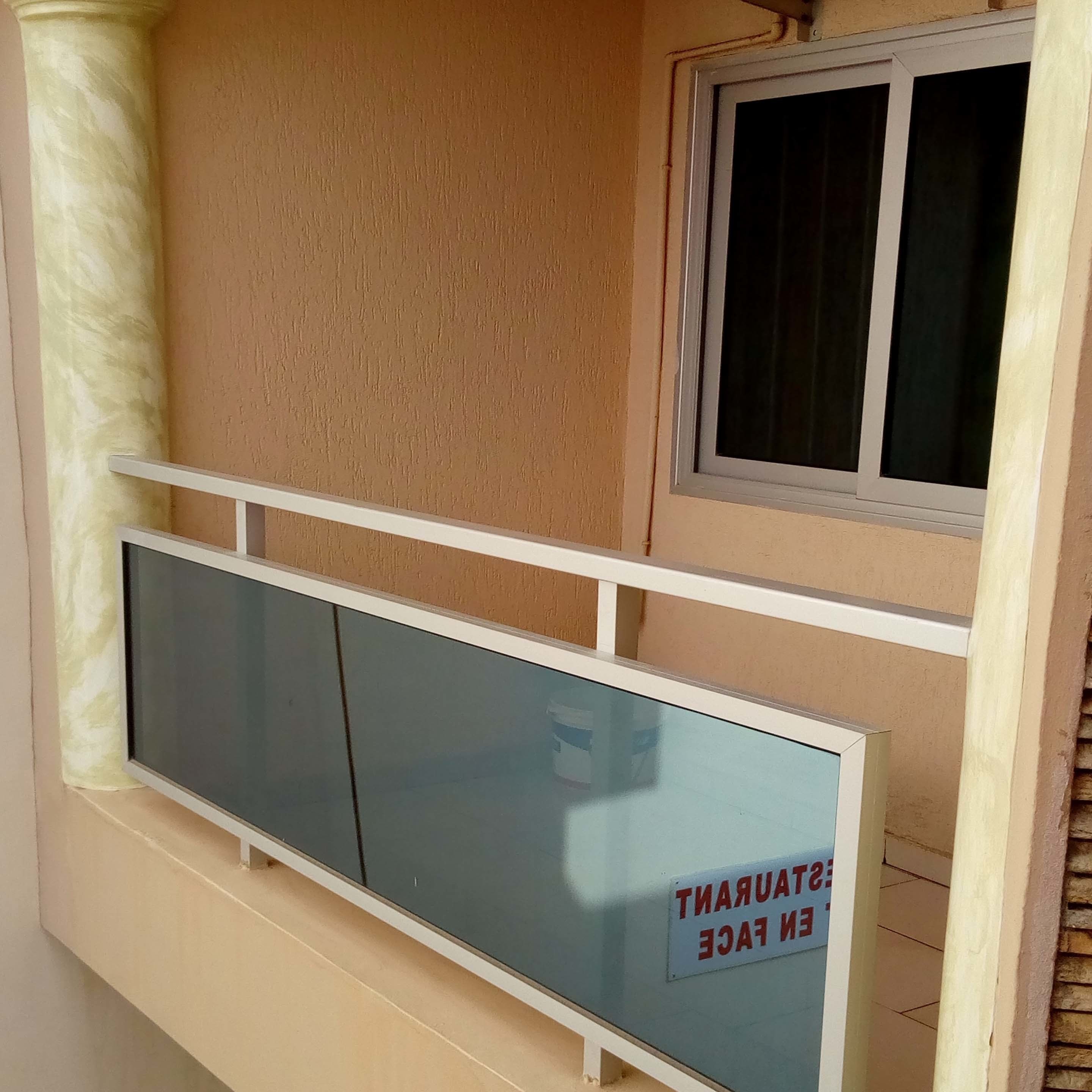 Quarto com uma janela grande, corrimão branco e uma placa com a inscrição 'STAFF ONLY'.