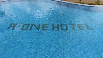 Uma piscina com a inscrição "A-ONE HOTEL" na superfície da água.