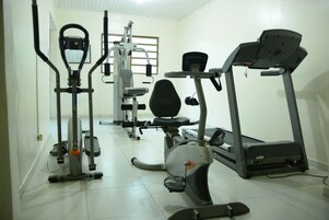 Uma academia com diversos equipamentos de exercício, incluindo esteiras, bicicletas ergométricas e aparelhos de musculação.