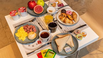 Mesa de café da manhã com diversos alimentos e acompanhamentos.