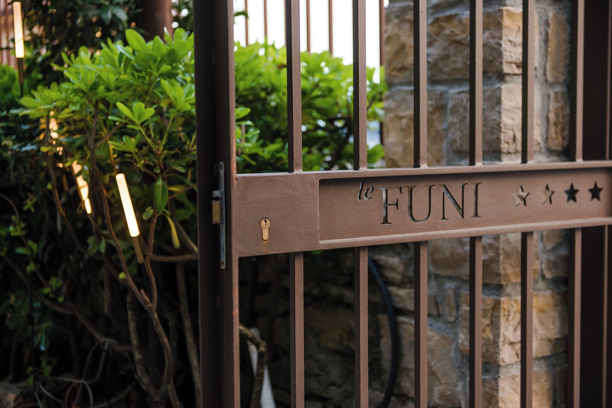 Um portão de metal com a inscrição 'le FUNI' e uma fechadura.