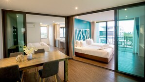 Quarto de hotel moderno com mesa de jantar de madeira, duas camas e varanda com vista.